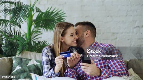 스마트폰 및 인터넷 쇼핑 신용 카드와 함께 매력적인 젊은 부부 집에서 거실에서 소파에 앉아 20 29세에 대한 스톡 사진 및 기타 이미지 20 29세 거실 고객