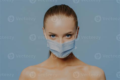 Studio Shot Of Naked European Woman Wears Disposable Medical Mask As