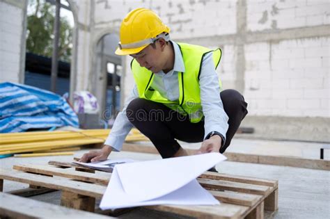 Young Asian Engineer In Engineering Uniform And Helmet At Construction