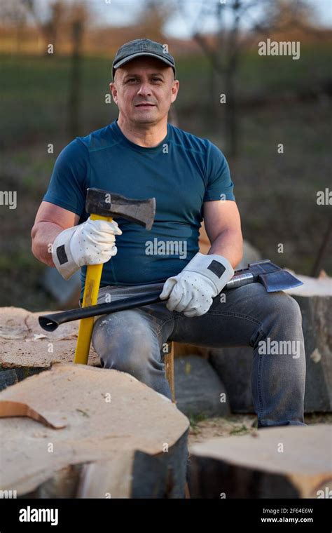 Woodman With Axes Resting After Splitting Logs In The Evening Stock