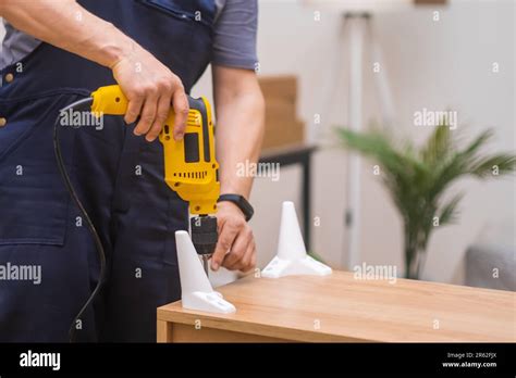 Furniture Assembler Completing Wooden Rack Attaching Legs With