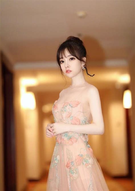 她是斗鱼一姐冯提莫，今穿粉色轻纱长裙，绑丸子头配小辫俏皮十足