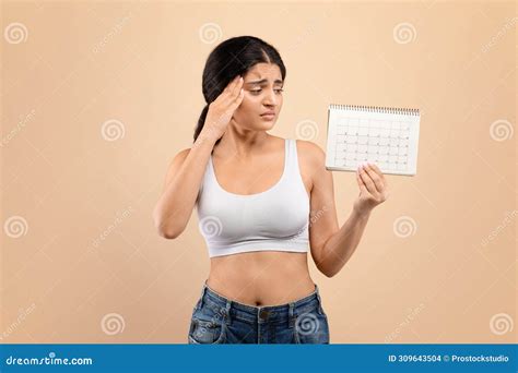 Concerned Young Indian Woman Holding Blank Menstrual Cycle Calendar