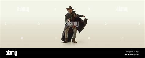 Man Cowboy In Long Leather Coat Dynamically Drawing Gun Coat Flowing