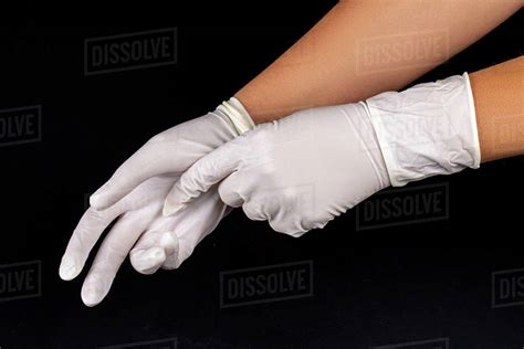 White Latex Medical Gloves On A Womans Hands On Dark Background
