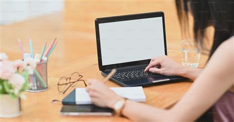 자른 이미지 여자는 나무 작업 책상에서 흰색 빈 화면 컴퓨터 노트북을 사용하고 있습니다 사진 Unsplash의 컴퓨터 키보드 이미지