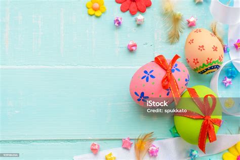 행복 한 부활절 레드 리본으로 부활절 달걀의 화려한 고 종이 꽃과 파스텔 컬러 밝은 녹색 및 배경에 흰색 나무 종이 스타의