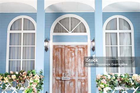 집에서 야외에서 아치형 창문 다른 꽃이 있는 집의 나무 현관 여름 집의 테라스 꽃이 만발한 봄 디자인 집 부활절을 위해 장식된 집의 집 입구 계단 꽃 식물에 대한 스톡 사진