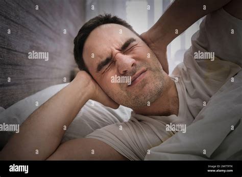 Annoyed Husband Blocking His Ears From Noise Of Wife Snoring In The