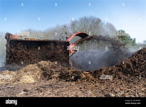 Turning A Manure Heap Over To Make Compost To Spread On Farmland Which