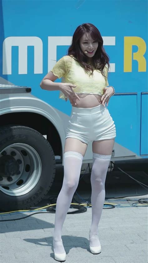 A Woman In Short White Shorts And Tights Standing Next To A Blue Bus