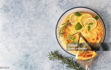 로즈마리 민트 레몬 조각으로 장식된 레몬 바닐라 치즈케이크 리코타 에는 크러스트 치즈케이크나 캐서롤이 없습니다 파란색 콘크리트