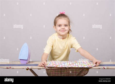 A Five Year Old Girl Playing In A Housewife And Stroking Things Iron