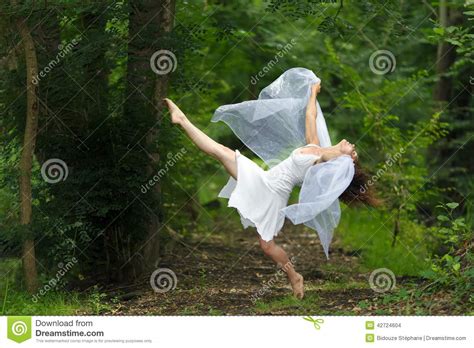 Graceful Barefoot Ballerina In A Business Suit Jumping With A Glass Of