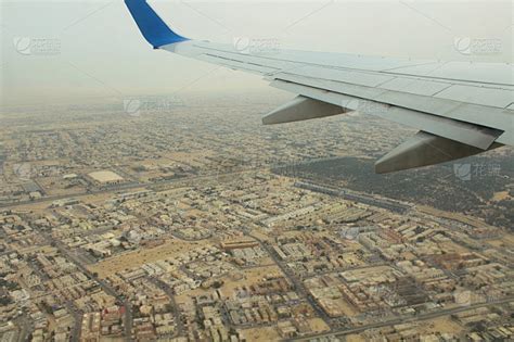 飞机在迪拜上空飞行在城市上空起飞从舷窗往外看翼飞机特写背景