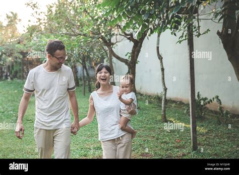 Parent With Their Cute Baby Walking Together In The Park Stock Photo Alamy