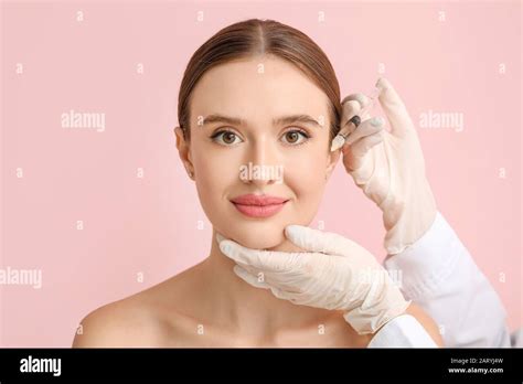 Young Woman Receiving Filler Injection Against Color Background Stock