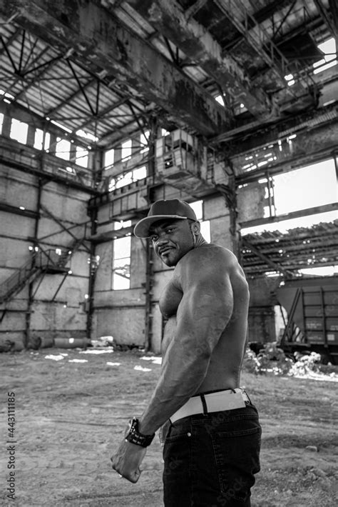 Foto De Muscular Young Bodybuilder With Naked Torso Posing For Camera