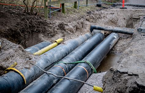 건설 현장에서 굴착된 도랑에 설치되는 대형 검은색 지하 파이프 하수에 대한 스톡 사진 및 기타 이미지 하수 하수 처리장 한 줄로 Istock