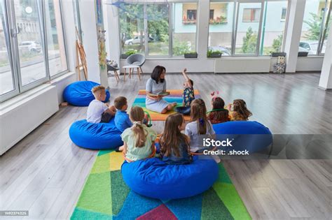 초등학교 또는 유치원에서의 독서 시간 초등학교 또는 유치원의 어린이들에게 책을 읽어주는 교사 유치원 교육의 개념 선택적 초점 고등학교 이하에 대한 스톡 사진 및 기타 이미지