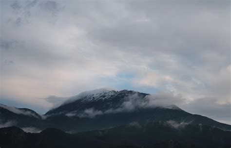 Os Picos Das Montanhas Na Neve Envolta Em Nuvens Fundo Natural A Ideia