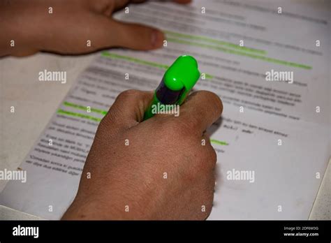Female Hand Holding Highlighter Pen Highlighting Marking Important Texts In Study Sheets On