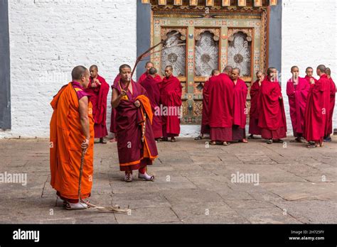 A Group Of Buddhist Monks In A Courtyard In The Punakha Dzong In