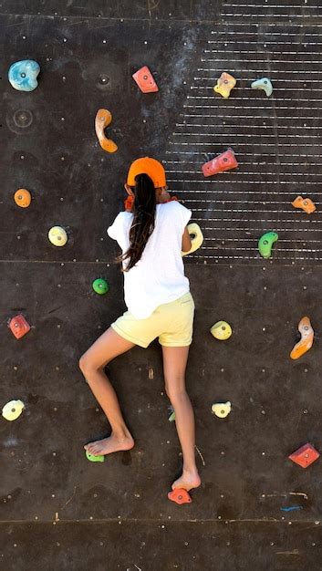 L Enfant Grimpe Au Sommet Du Mur D Escalade Fermer Photo Premium