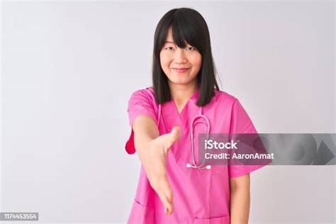 젊은 아름다운 중국 간호사 여성 은 인사와 환영으로 악수를 제공 친근한 미소 고립 된 흰색 배경 위에 청진기를 입고 성공적인 비즈니스 간호사에 대한 스톡 사진 및 기타