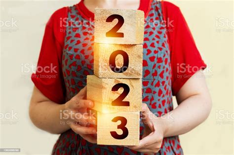2023년 3d 나무 큐브에 2023년을 들고 있는 클로즈업 여성 2023년 새해 인사말 카드 템플릿 2023년에 대한 스톡