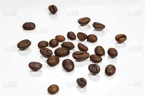 咖啡豆被隔离在反射的白色表面上