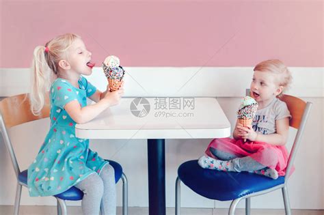 两个快乐的高加索可爱有趣的儿童女孩坐在一起吃舔着五颜六色的冰淇淋的生活方式肖像爱嫉妒友情美高清图片下载 正版图片503940566 摄图网