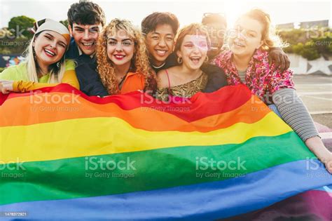 야외에서 Lgbt 무지개 깃발을 들고 즐거운 시간을 보내는 다양한 젊은이들 가운데 소녀 얼굴에 집중 단체에 대한 스톡 사진 및