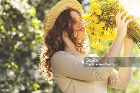 모든 여자는 꽃을 사랑 한다 모자와 드레스 눈에 예쁘고 젊은 여자의 클로 우즈 업 초상화 폐쇄 하 고 웃 고 손에 꽃을 가까이 유지 하는 동안 얼굴 건강관리와 의술에 대한