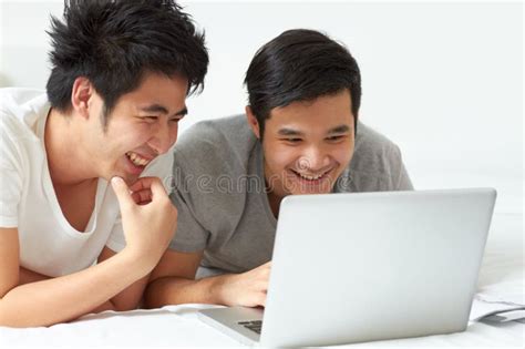 Lgbt Laptop And An Asian Couple In Bed Together Watching A Movie Or