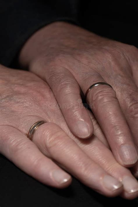 The Hands Of A Mature Newly Married Couple Showing Off Their Rings