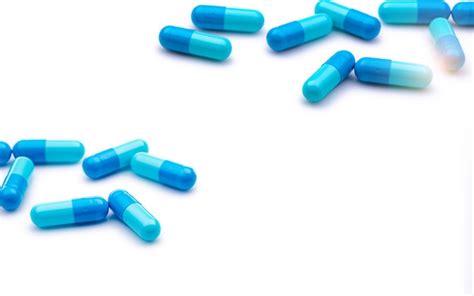 Comprimidos azuis da cápsula do antibiótico no fundo branco medicamentos de prescrição