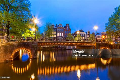 Kanal Amsterdam Dengan Rumah Khas Belanda Dan Jembatan Yang Diterangi