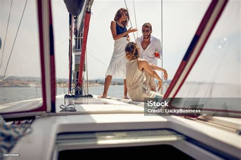 젊고 잘 생긴 모델 그룹이 해변의 요트 갑판에서 멋진 시간을 보내면서 즐거운 시간을 보내고 있습니다 여름 바다 휴가 우정 20 29세에 대한 스톡 사진 및 기타 이미지
