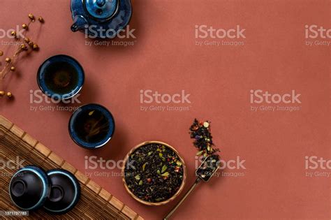 갈색 배경에 블루 주전자 차 한 잔과 차 잎 뜨거운 허브 차는 테이블의 주전자에 있습니다 공간을 복사합니다 0명에 대한 스톡