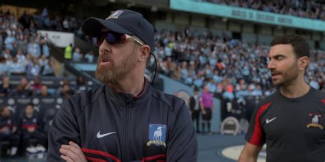 Oakley Sunglasses And Nike Track Jacket Worn By Brendan Hunt As Coach