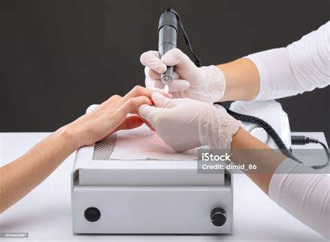 매니큐어의 주인은 미용실에서 손톱 연장 시술 중에 손톱 모양을 톱으로 부착합니다 손에 대한 전문적인 관리 가짜 속눈썹에 대한