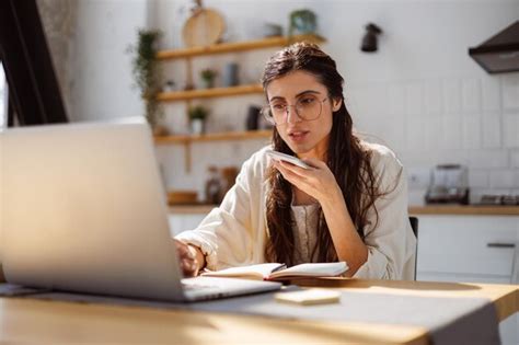 Premium Photo Woman In Eyeglasses Recording Voice Message On Smartphone And Using Laptop In