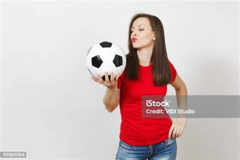 아름 다운 유럽 젊은 쾌활 한 행복 한 여자 축구 팬 또는 선수 붉은 유니폼 보류 키스 클래식 축구공 흰색 배경에 고립에서