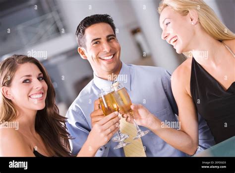 Portrait Of A Mid Adult Man Raising A Toast With Two Young Women Stock