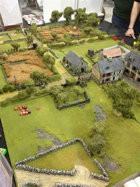 A Table That Has Some Model Houses On It And People Looking At The