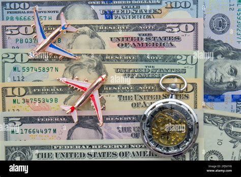 Passenger Planes And Pocket Watch Sitting On Us Currency Bills Of