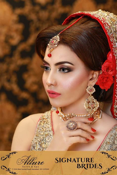 A Woman Wearing A Red And Gold Bridal Outfit With Flowers In Her Hair