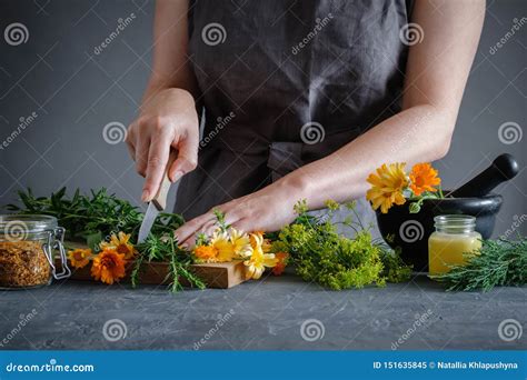 Herbalist Woman Chopping Medicinal Herbs With A Knife To Prepare