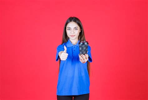 Jeune Femme Tenant Une Tasse De Café Jetable Noire Et Montrant Un Signe